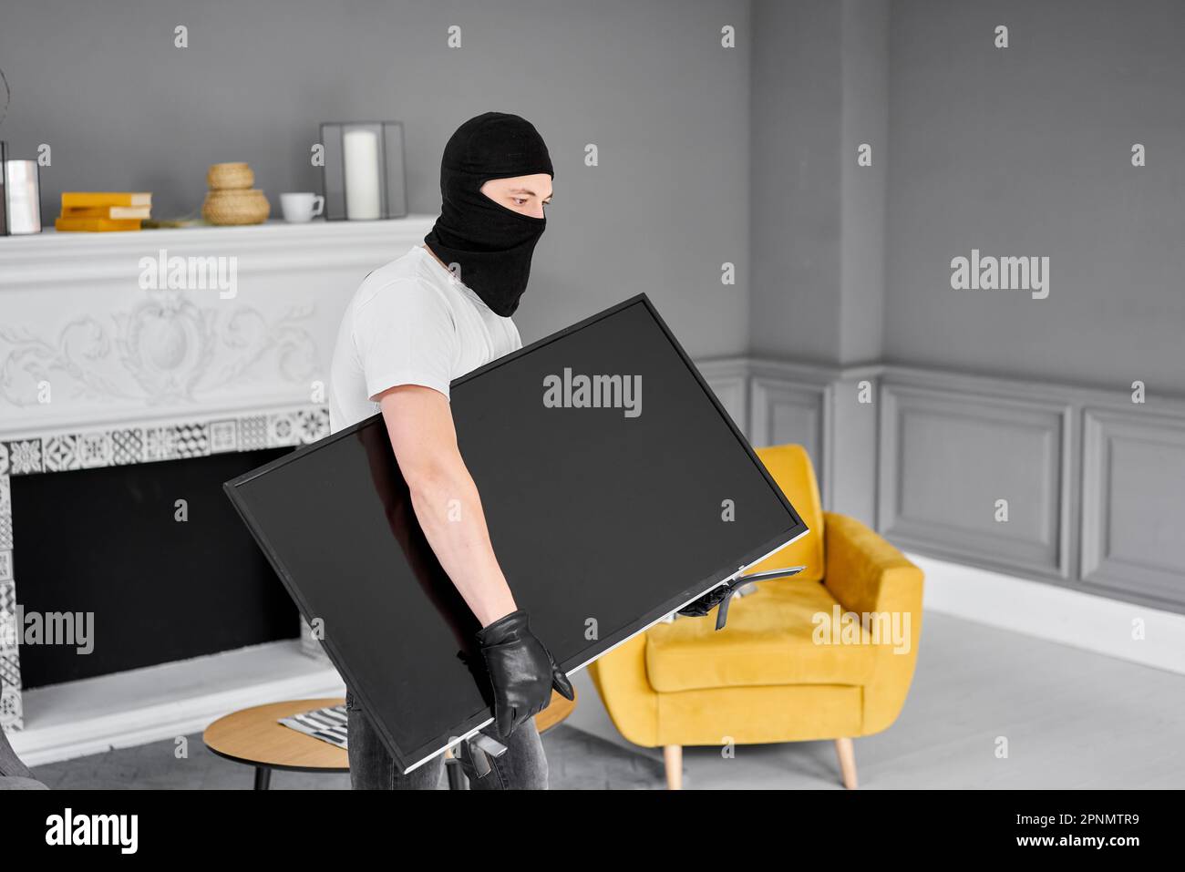 Thief with black balaclava stealing modern expensive television. Masked ...