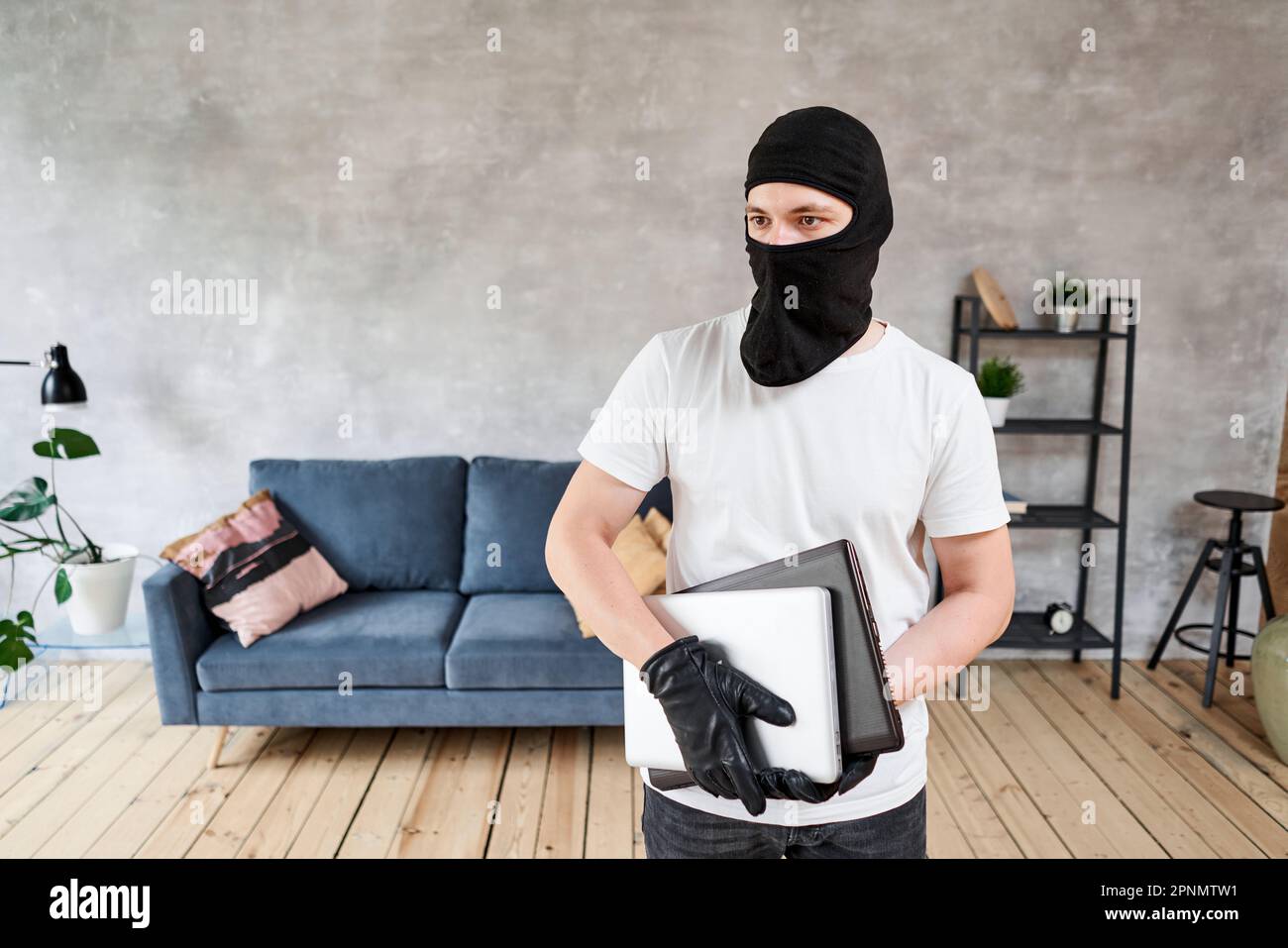 Masked face. Man burglar stealing tv set from house. Thief with black ...