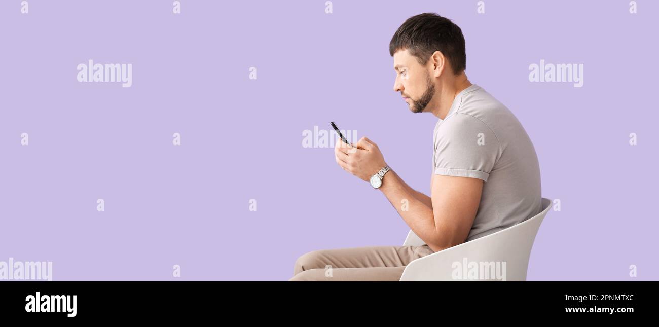 Man with bad posture using mobile phone while sitting on chair against ...