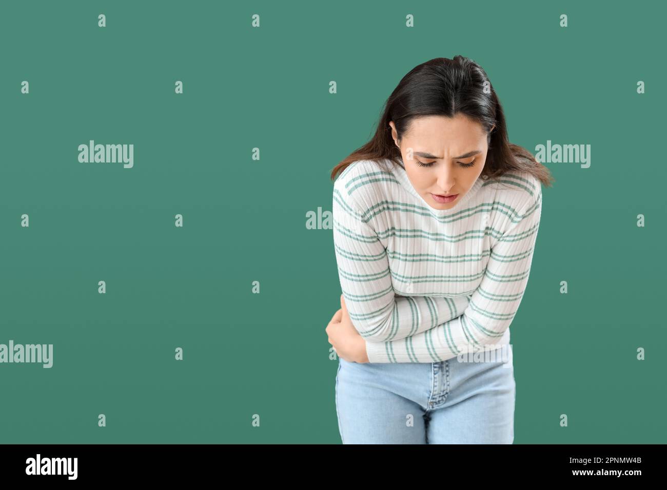 Young woman with appendicitis on green background Stock Photo - Alamy