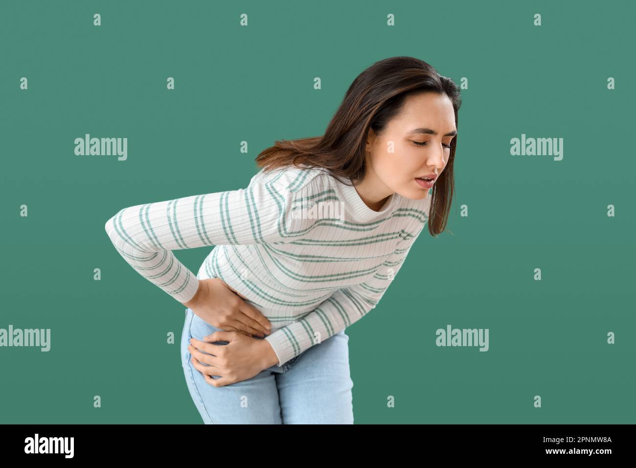 Young woman with appendicitis on green background Stock Photo - Alamy