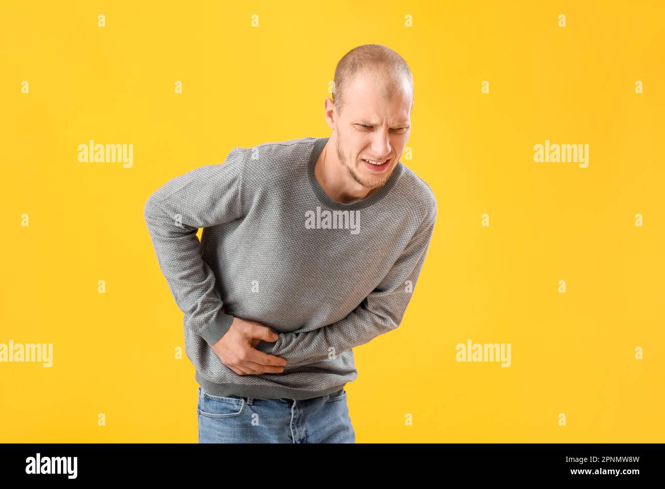 Young man with appendicitis on yellow background Stock Photo - Alamy
