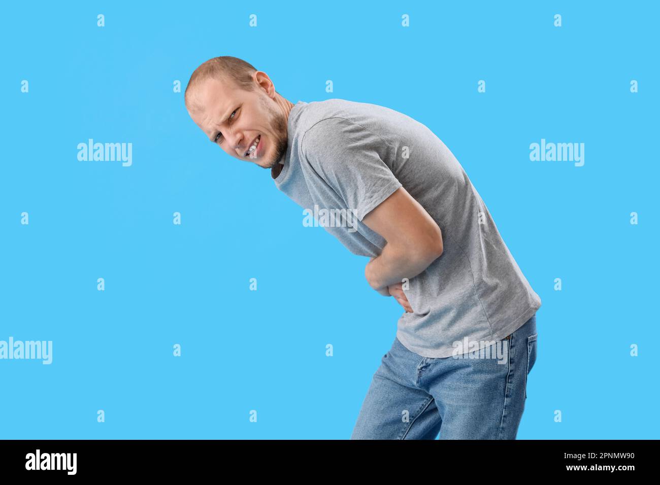Young man with appendicitis on blue background Stock Photo - Alamy