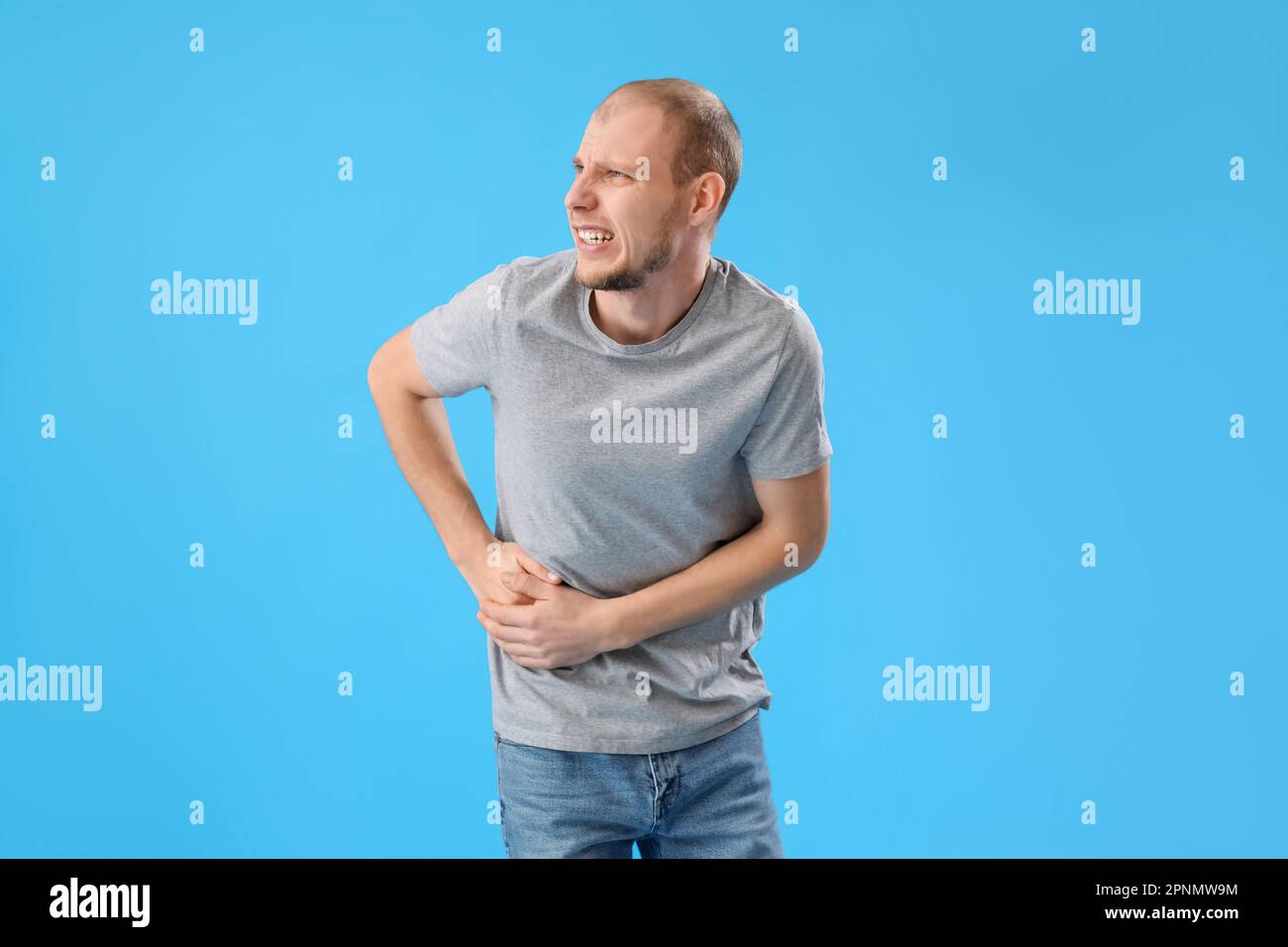 Young man with appendicitis on blue background Stock Photo - Alamy