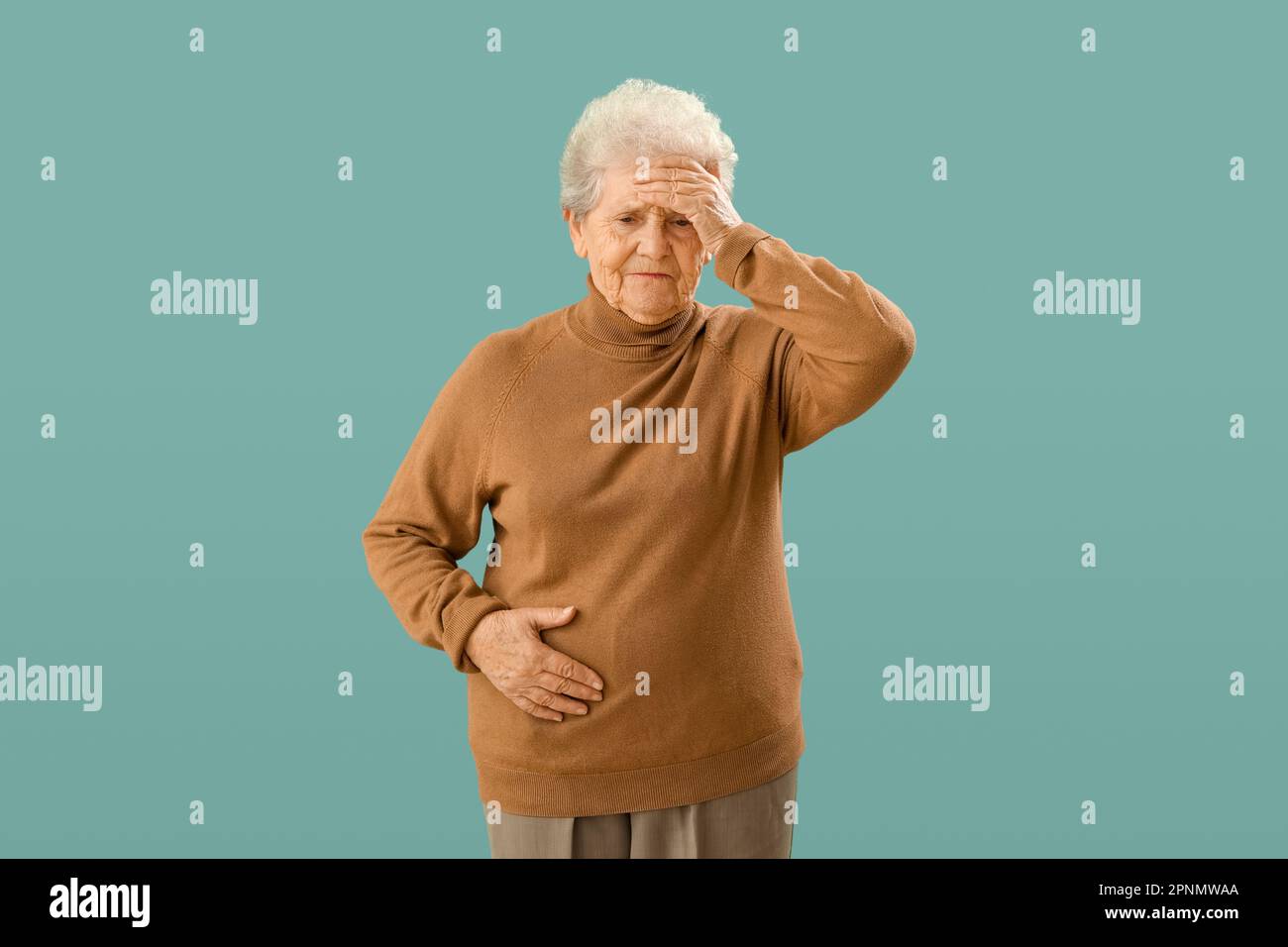Senior woman with appendicitis on green background Stock Photo - Alamy