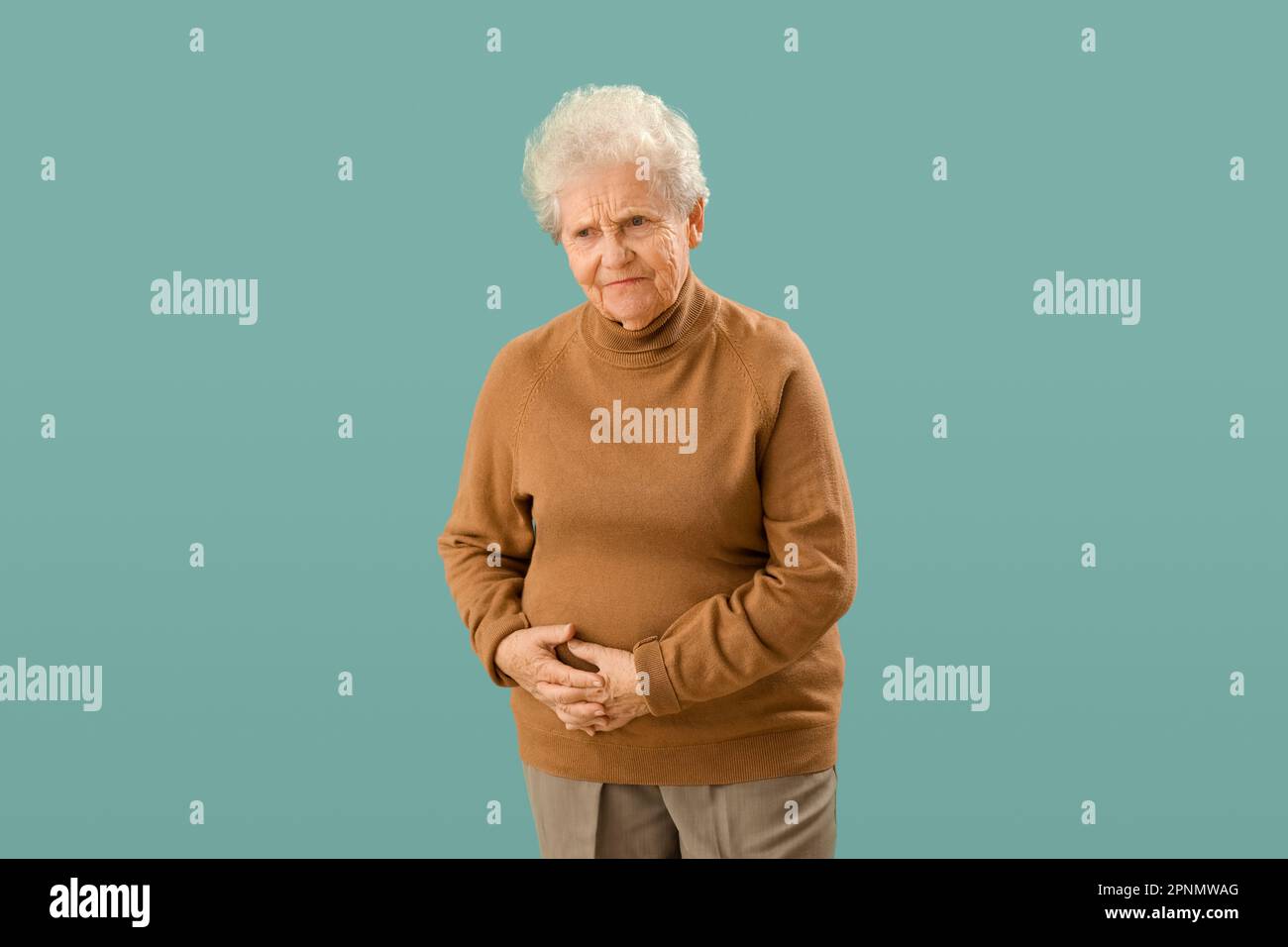 Senior woman with appendicitis on green background Stock Photo - Alamy