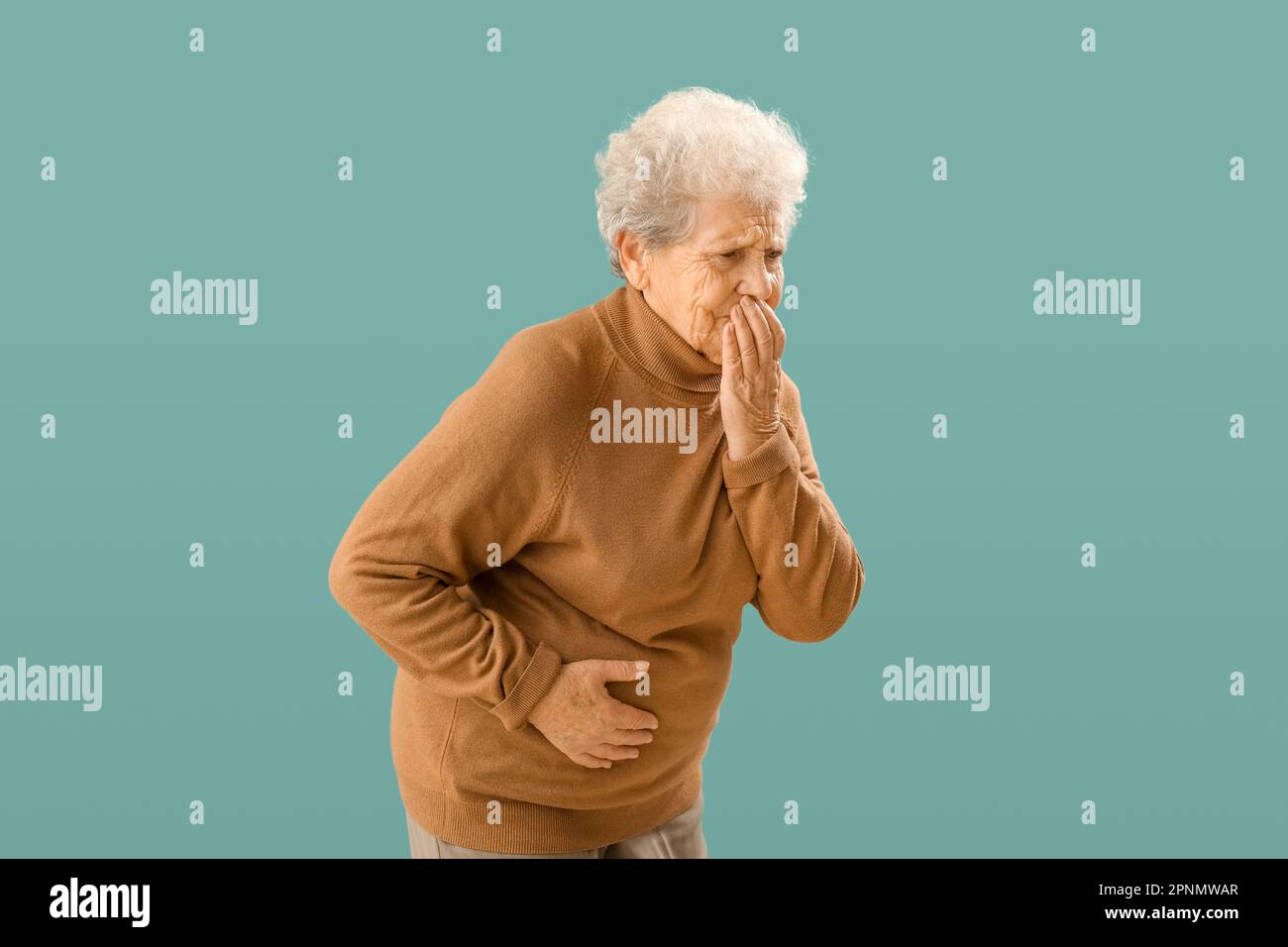 Senior woman with appendicitis on green background Stock Photo - Alamy