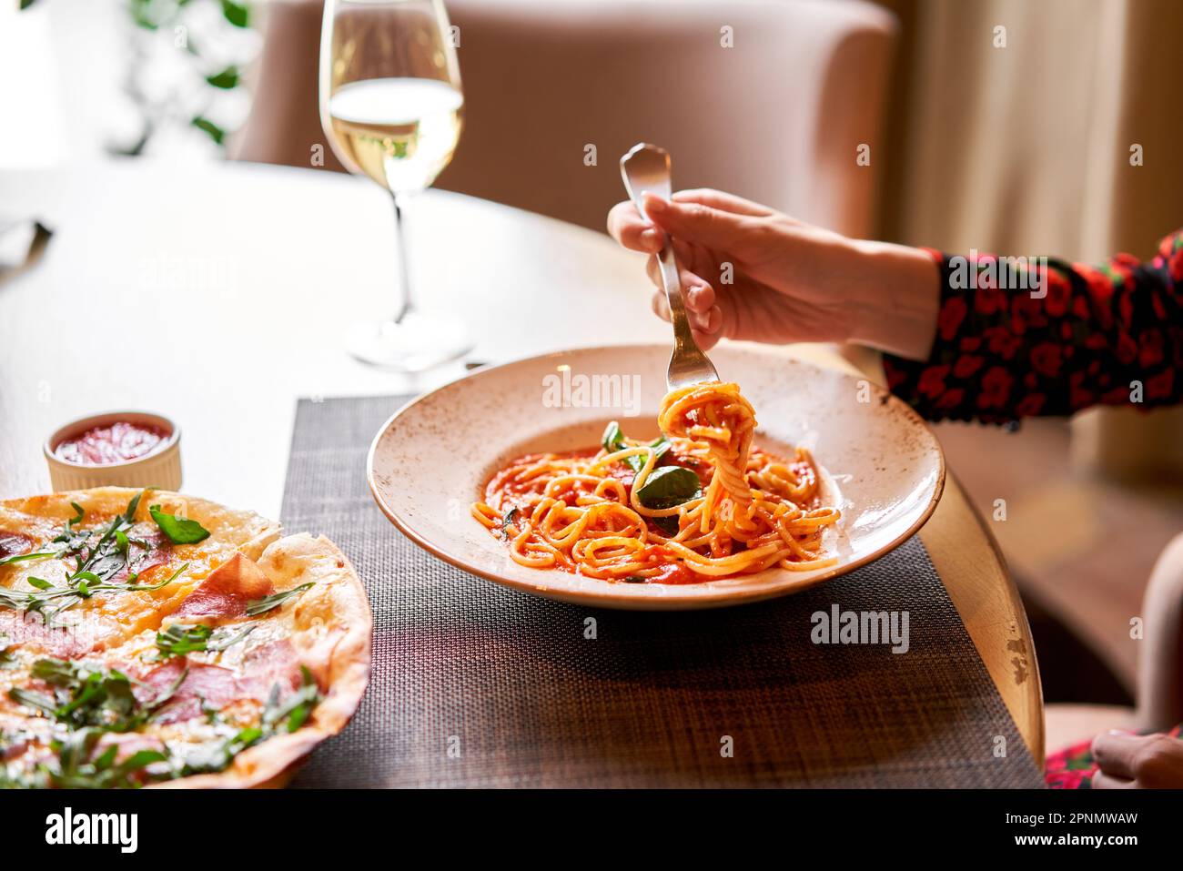 Italian Trattoria. Woman eats Italian pasta with tomato, meat ...