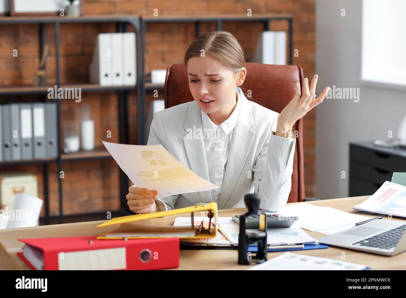 Stressed female accountant with document at table in office Stock Photo ...