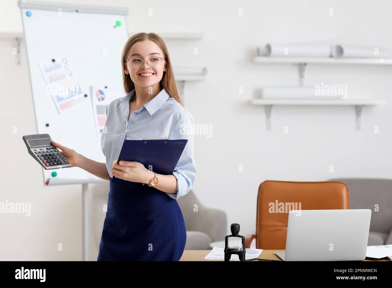 Female accountant with calculator and clipboard in office Stock Photo ...