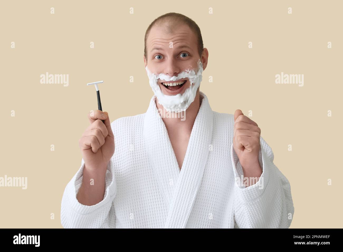 Happy young man shaving against beige background Stock Photo - Alamy
