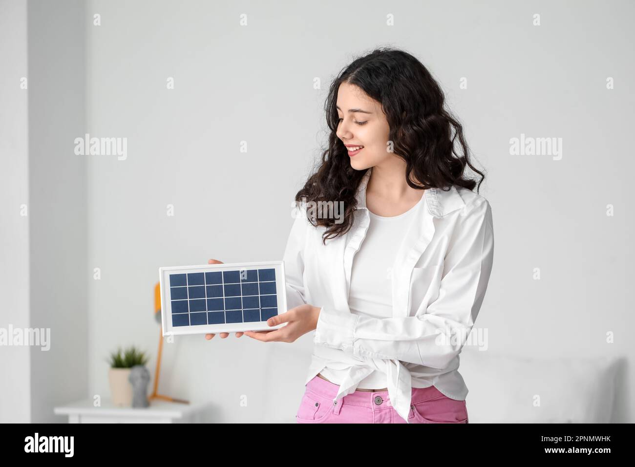 Teenage girl with portable solar panel in bedroom Stock Photo - Alamy