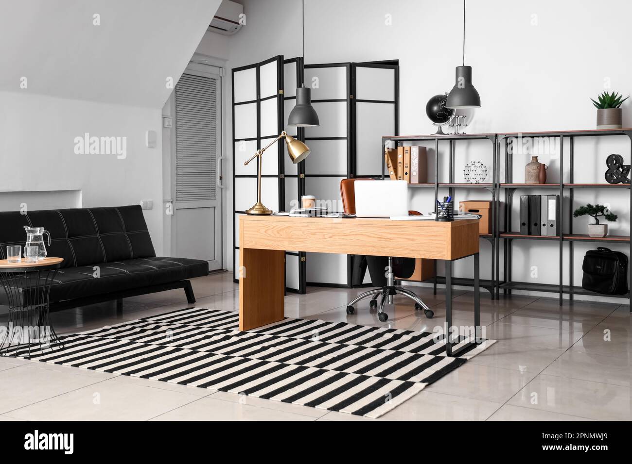 Interior of modern office with workplace, shelving unit and couch Stock ...