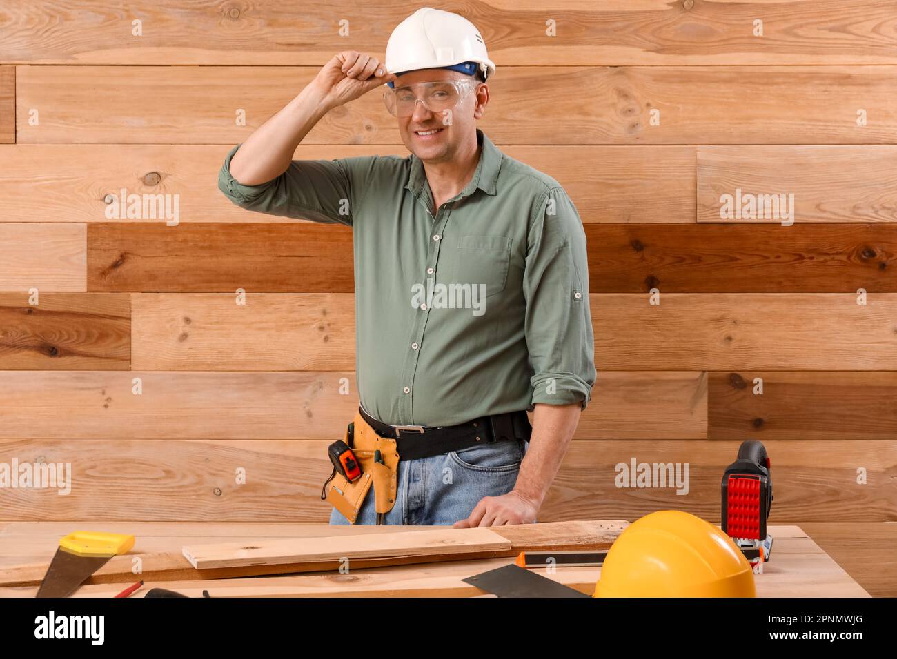 Mature carpenter at table near wooden wall Stock Photo - Alamy
