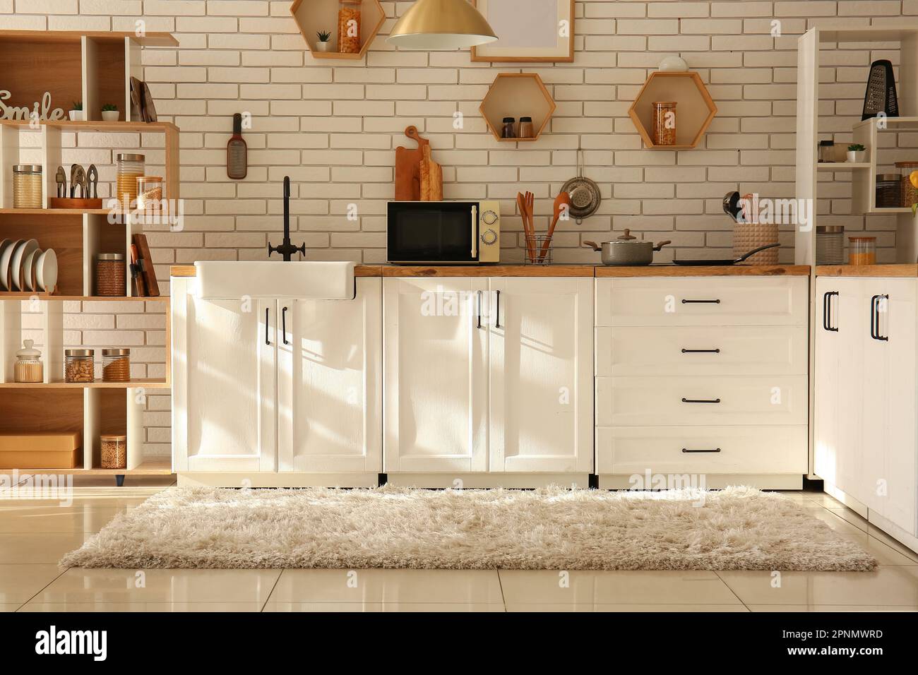 Interior of modern kitchen with counters near white brick wall Stock ...