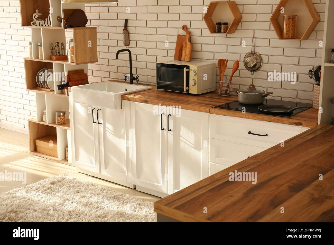 Interior of modern kitchen with counters near white brick wall Stock ...