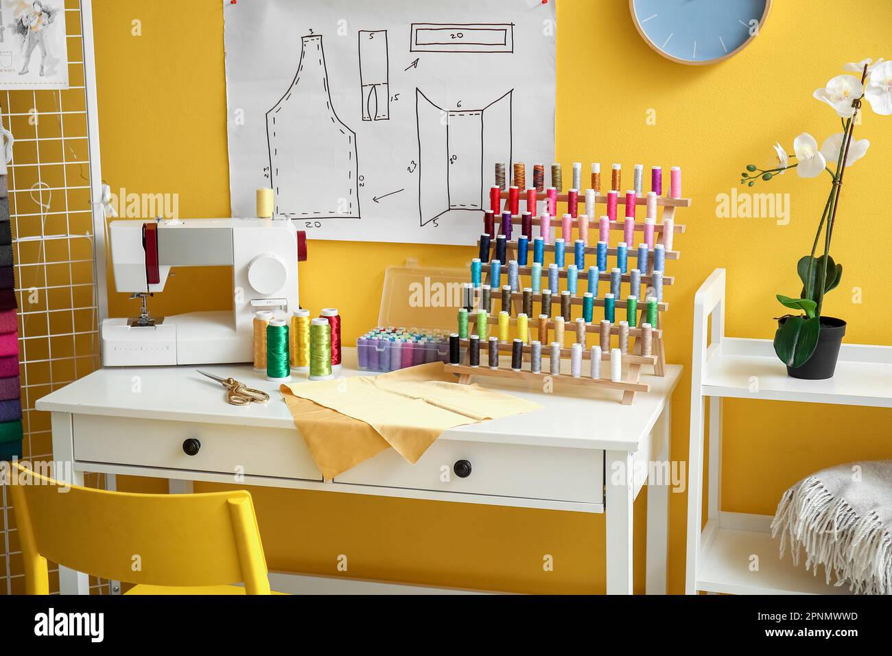 Tailor's workplace with sewing machine and thread spool in stylish ...