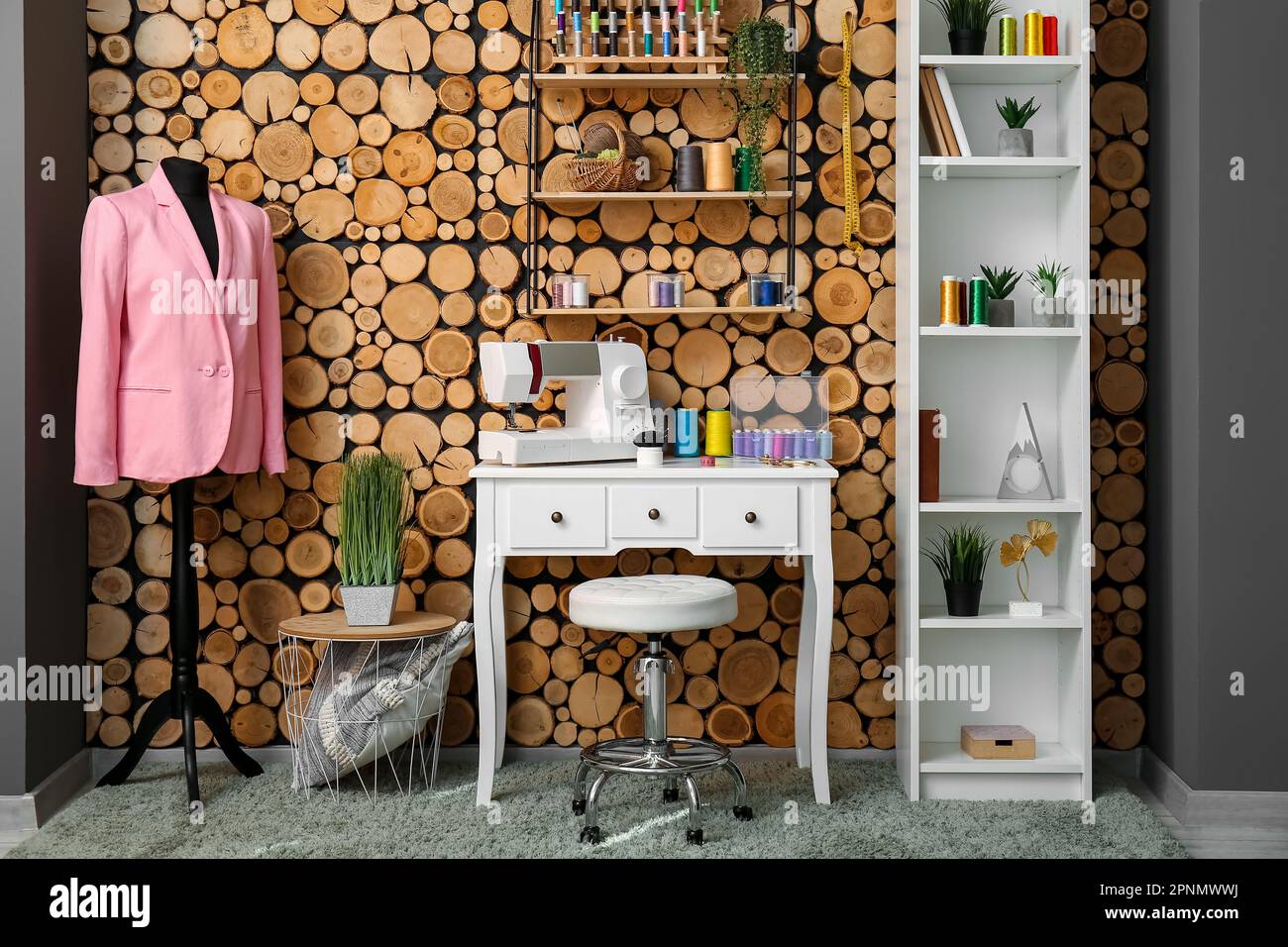 Interior of atelier with tailor's workplace, shelves and mannequin ...