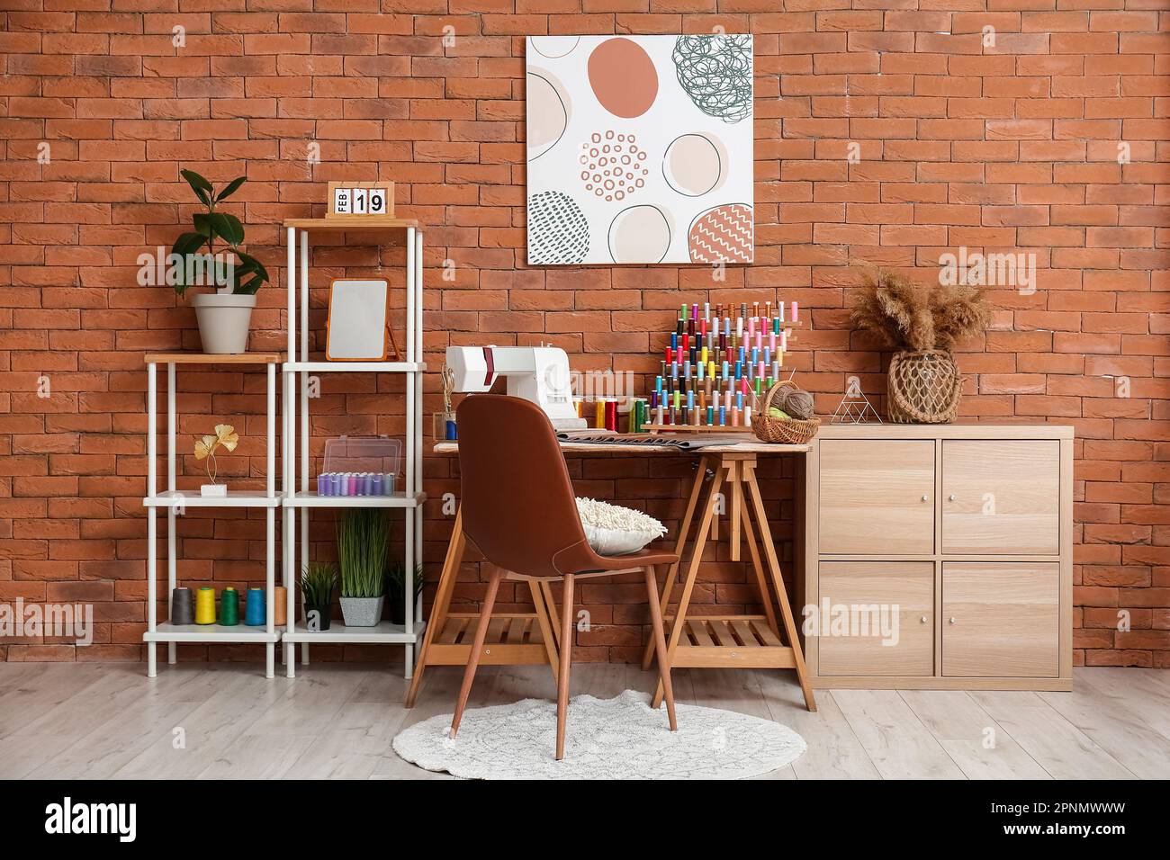 Interior of atelier with tailor's workplace, shelving units and drawers ...