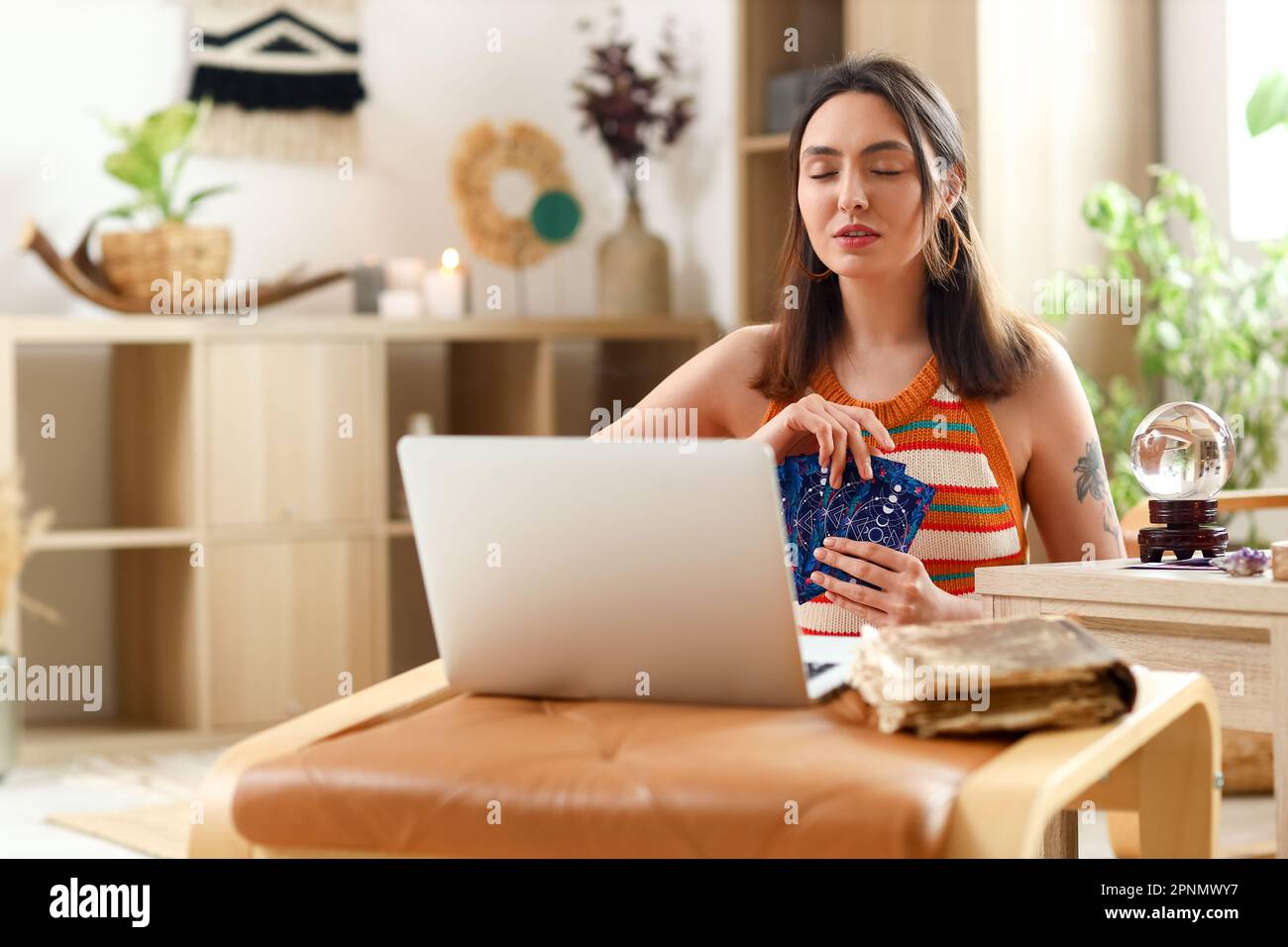 Young fortune teller with tarot cards recording video at home Stock ...