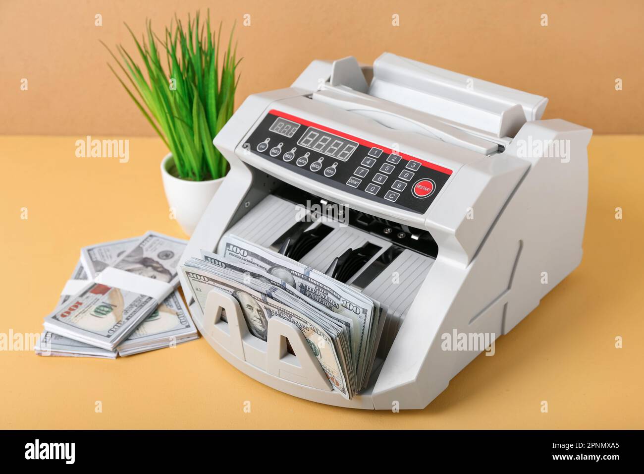 Modern cash counting machine with dollar banknotes on color background ...