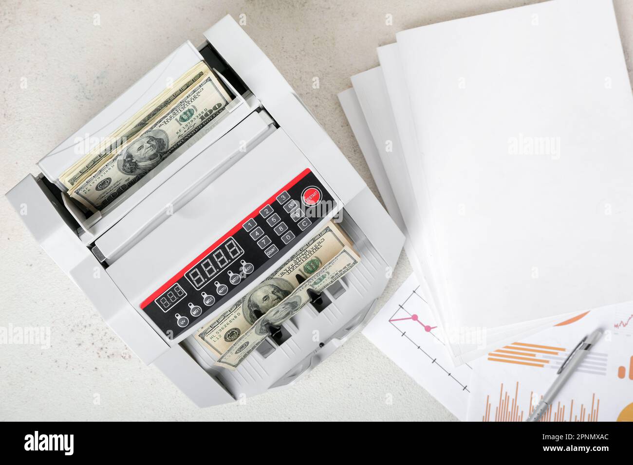 Modern cash counting machine with dollar banknotes and notebooks on ...
