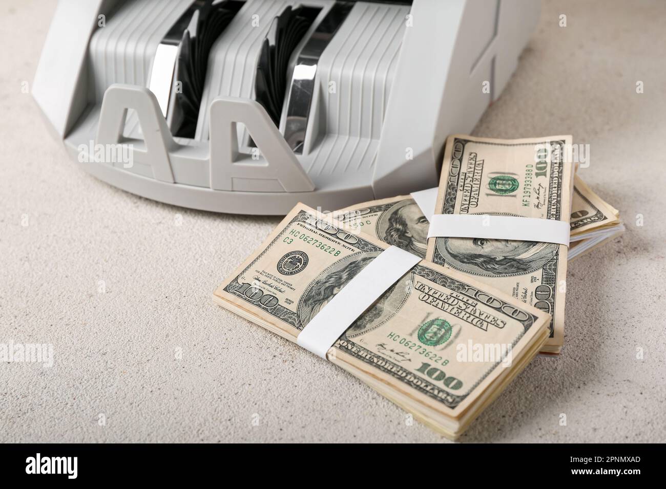 Dollar banknotes and modern cash counting machine on light background ...