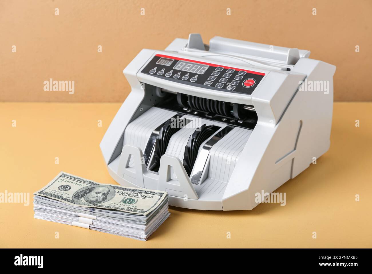 Modern cash counting machine with dollar banknotes on color background ...