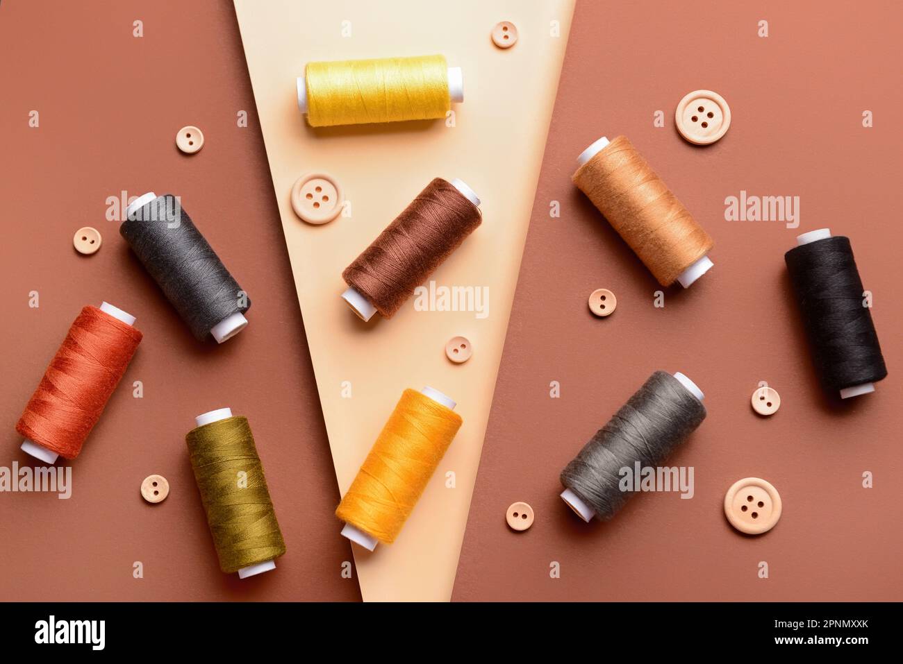 Composition with thread spools and buttons on color background Stock ...