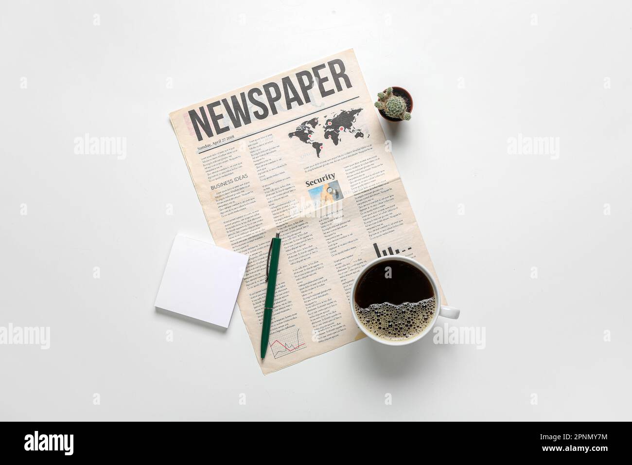 Newspaper with cup of coffee, sticky notes, pen and cactus on white ...