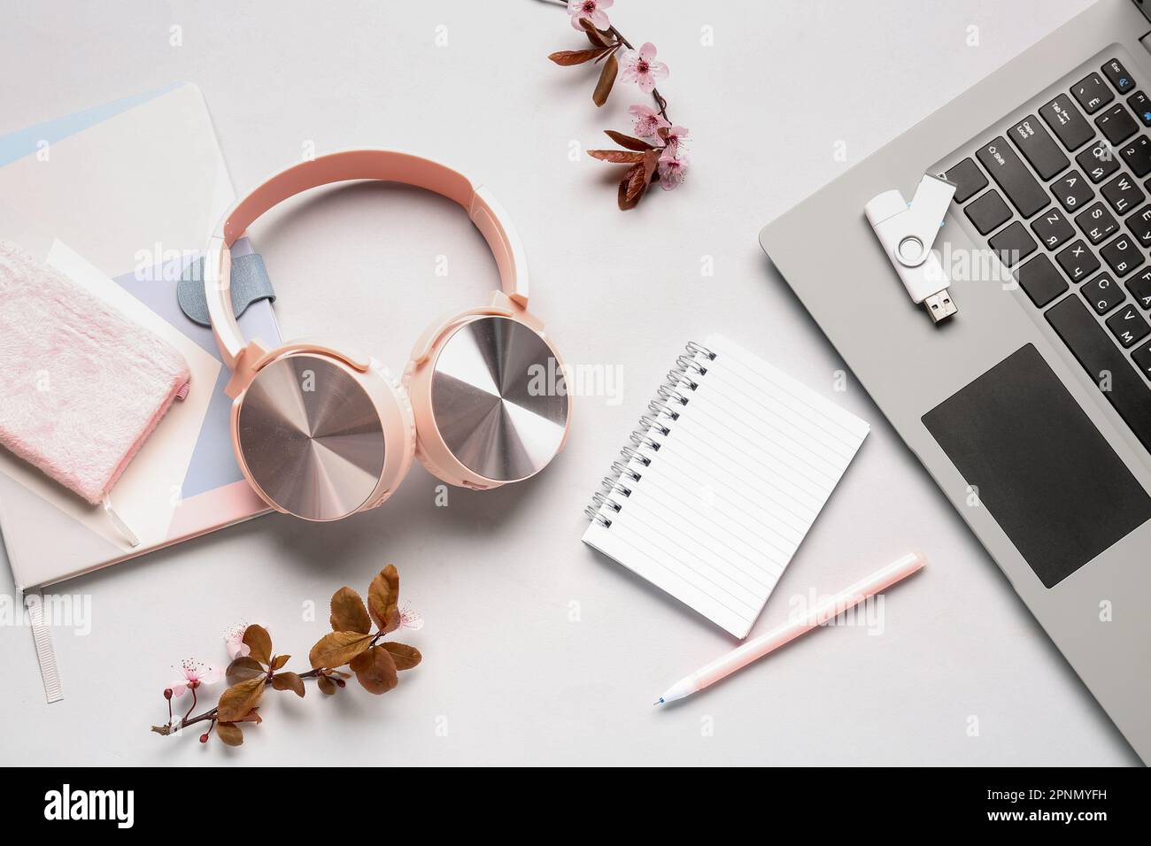 Composition with modern gadgets, notebooks and blooming tree branches ...