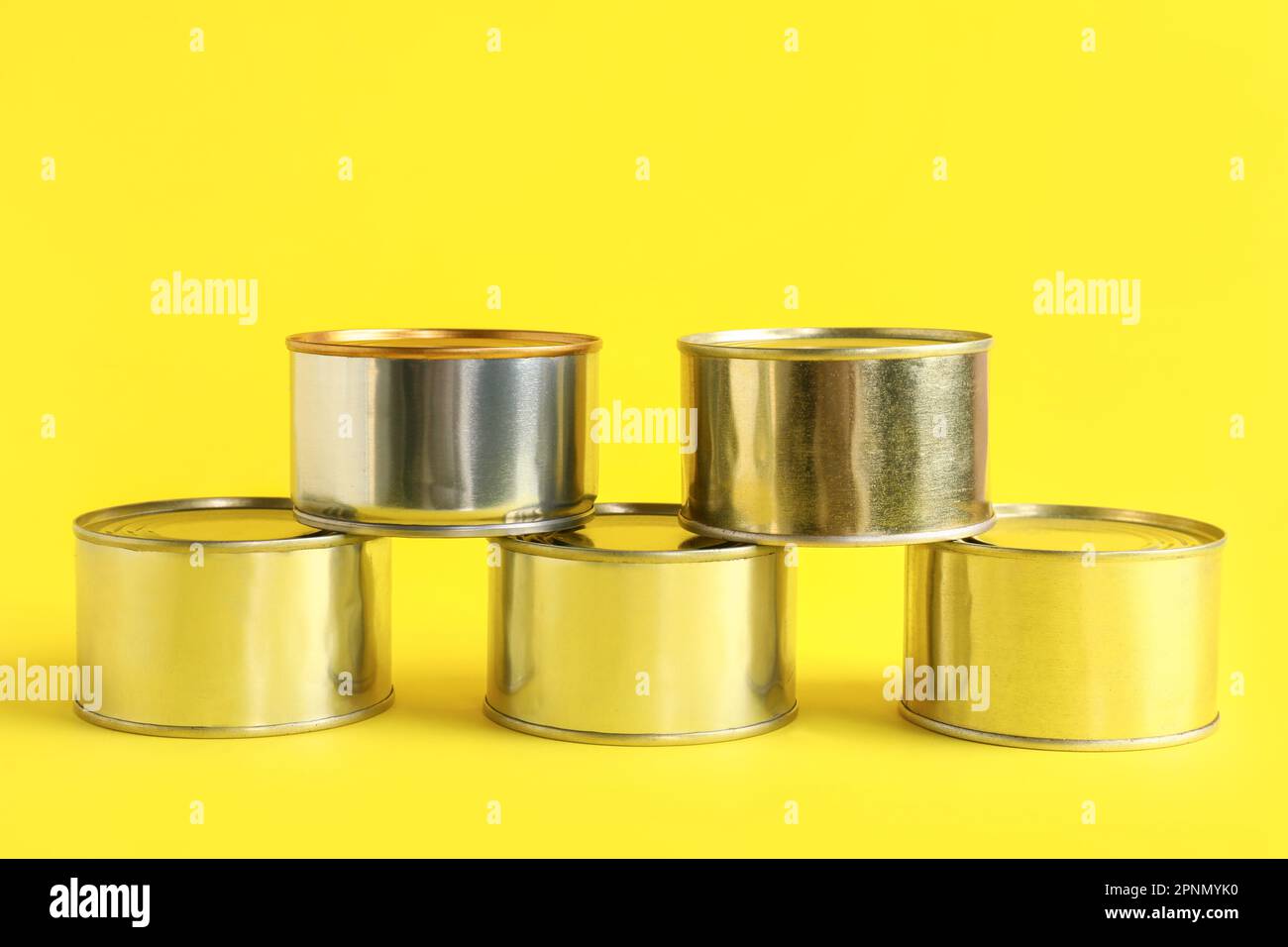 Tin cans with fish on yellow background Stock Photo - Alamy