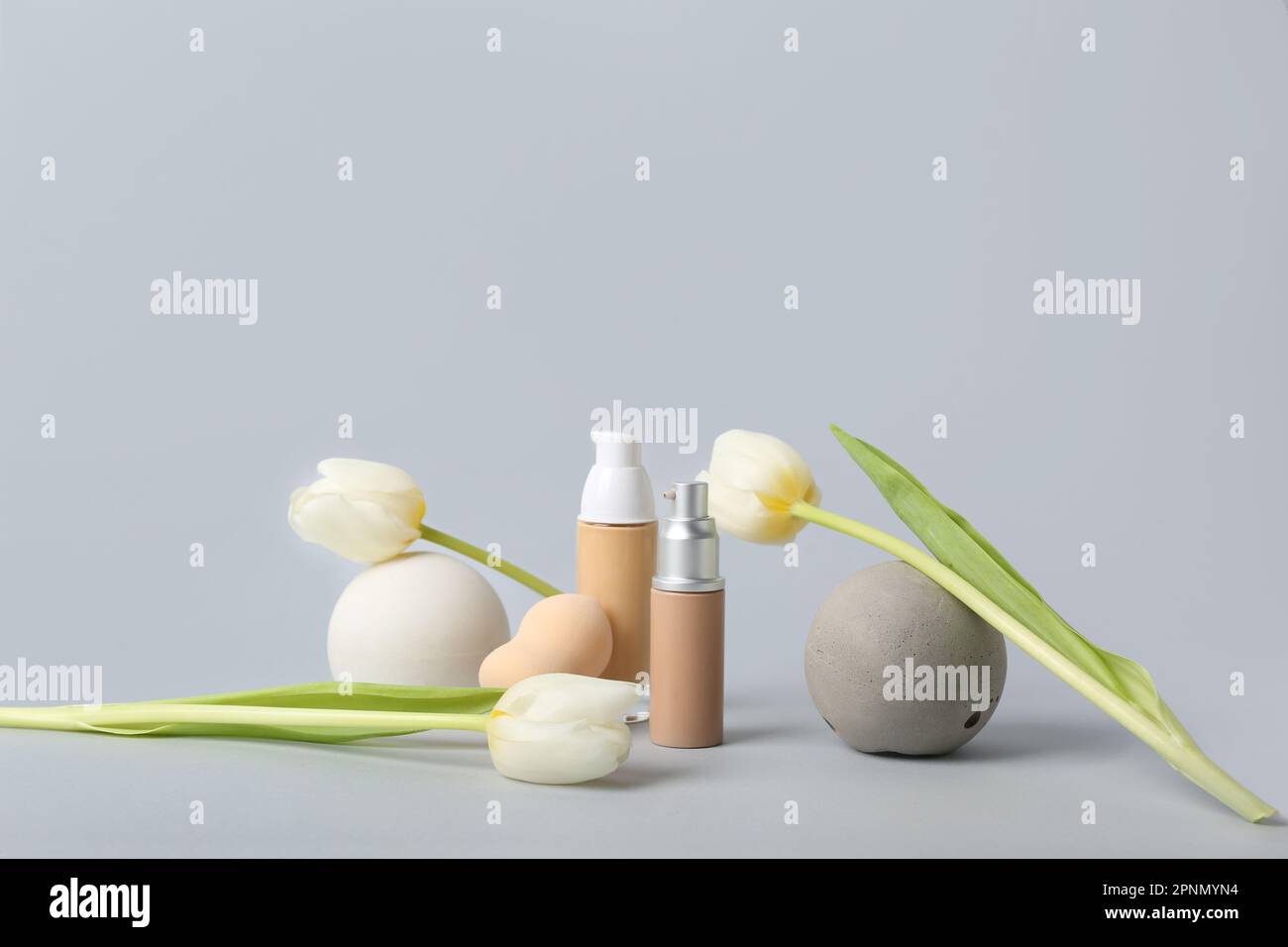 Decorative plaster podiums, bottles of makeup foundation and tulip ...