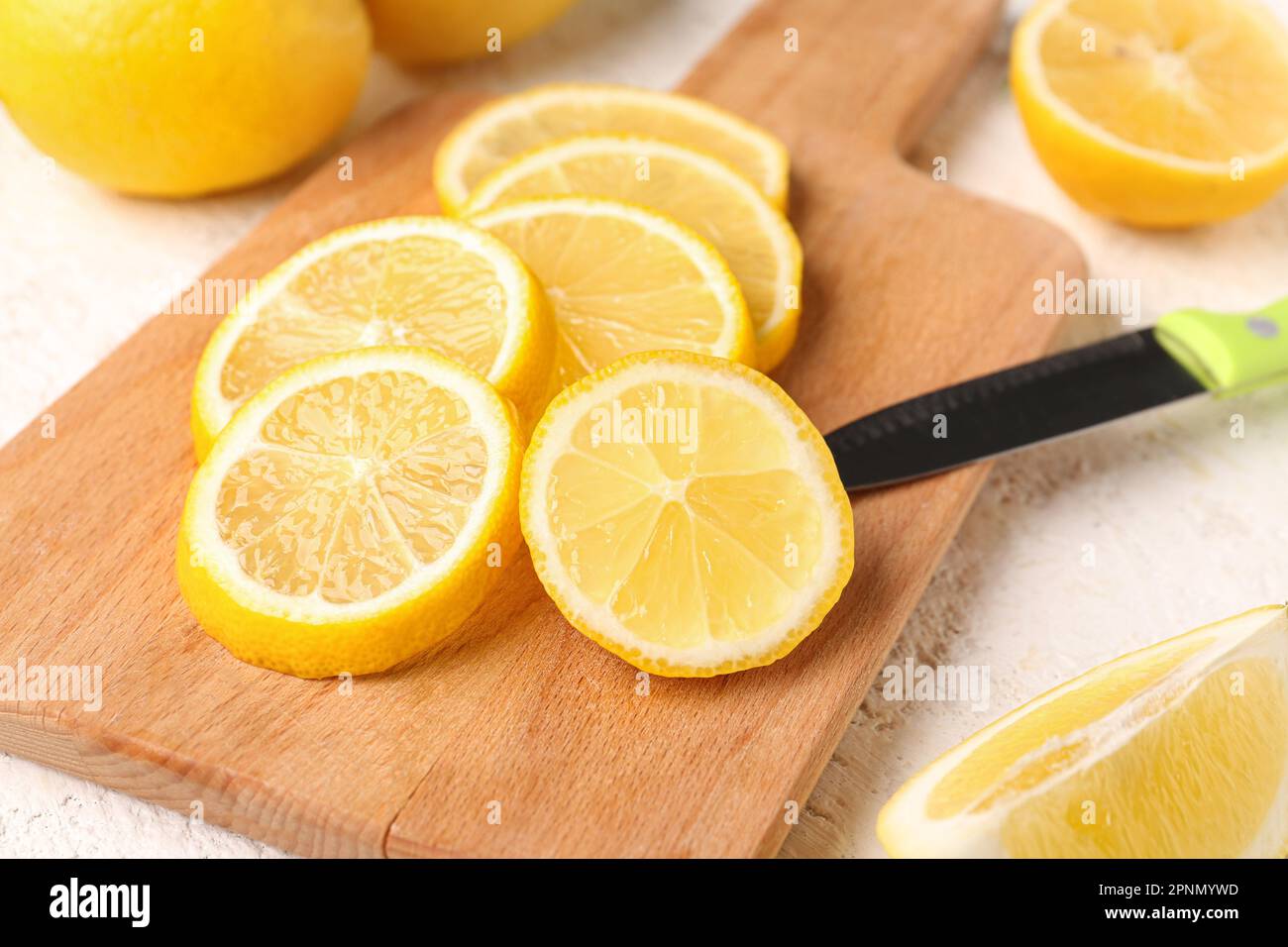 Board with fresh lemons on white background Stock Photo - Alamy