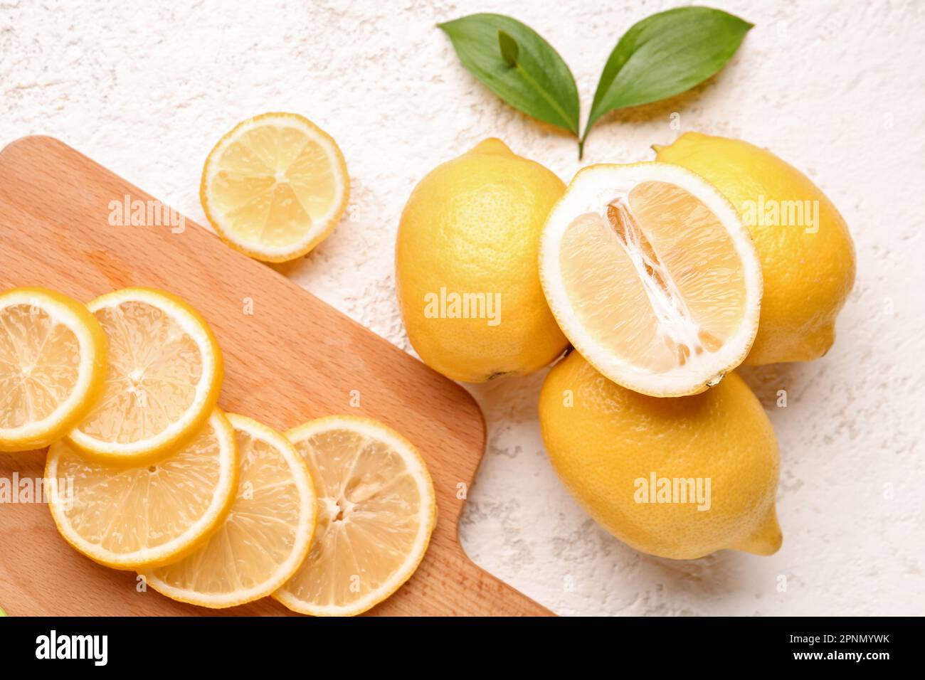 Board with fresh lemons on white background Stock Photo - Alamy