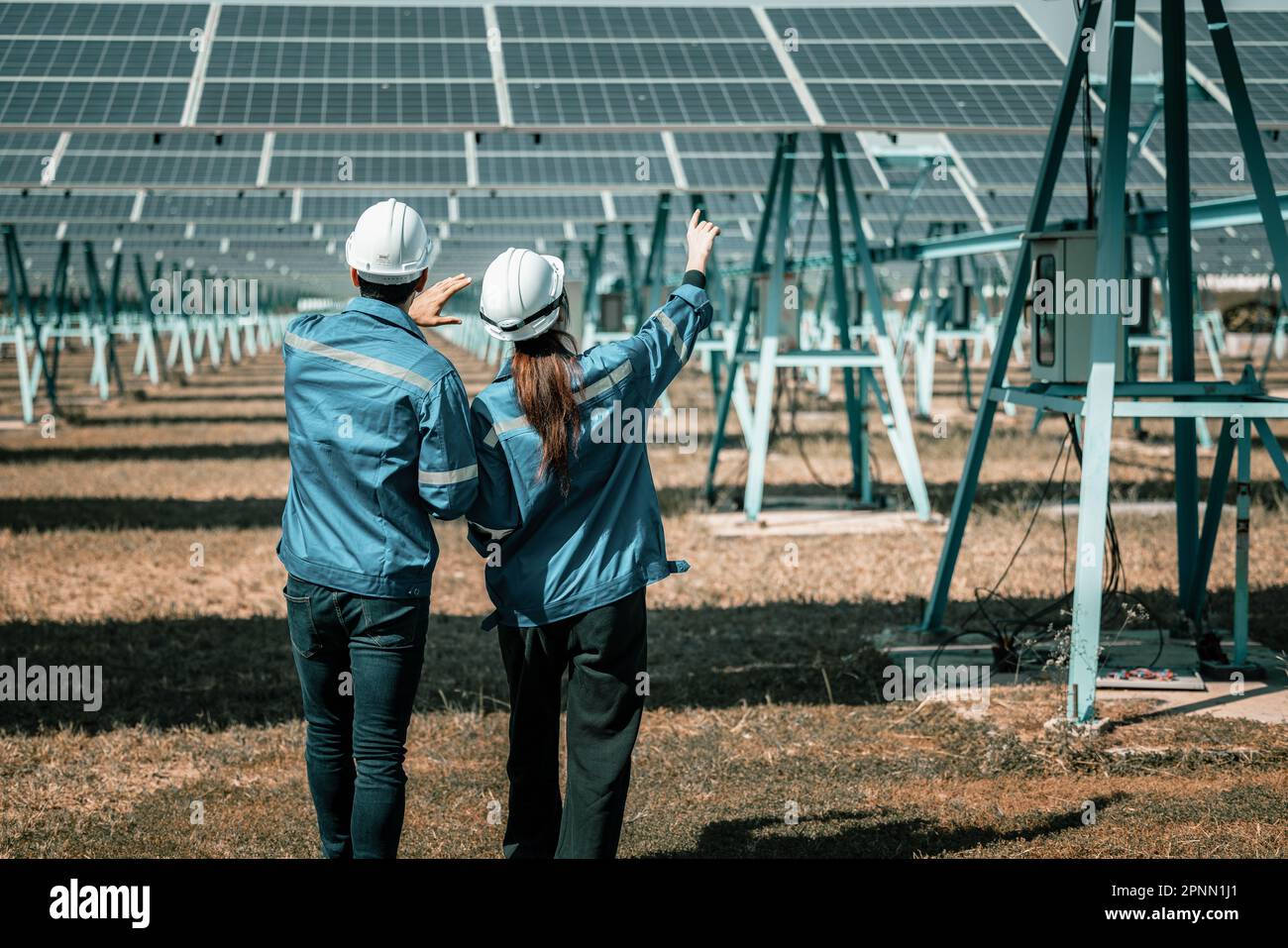 Solar design engineers visually inspect photovoltaic array installation ...