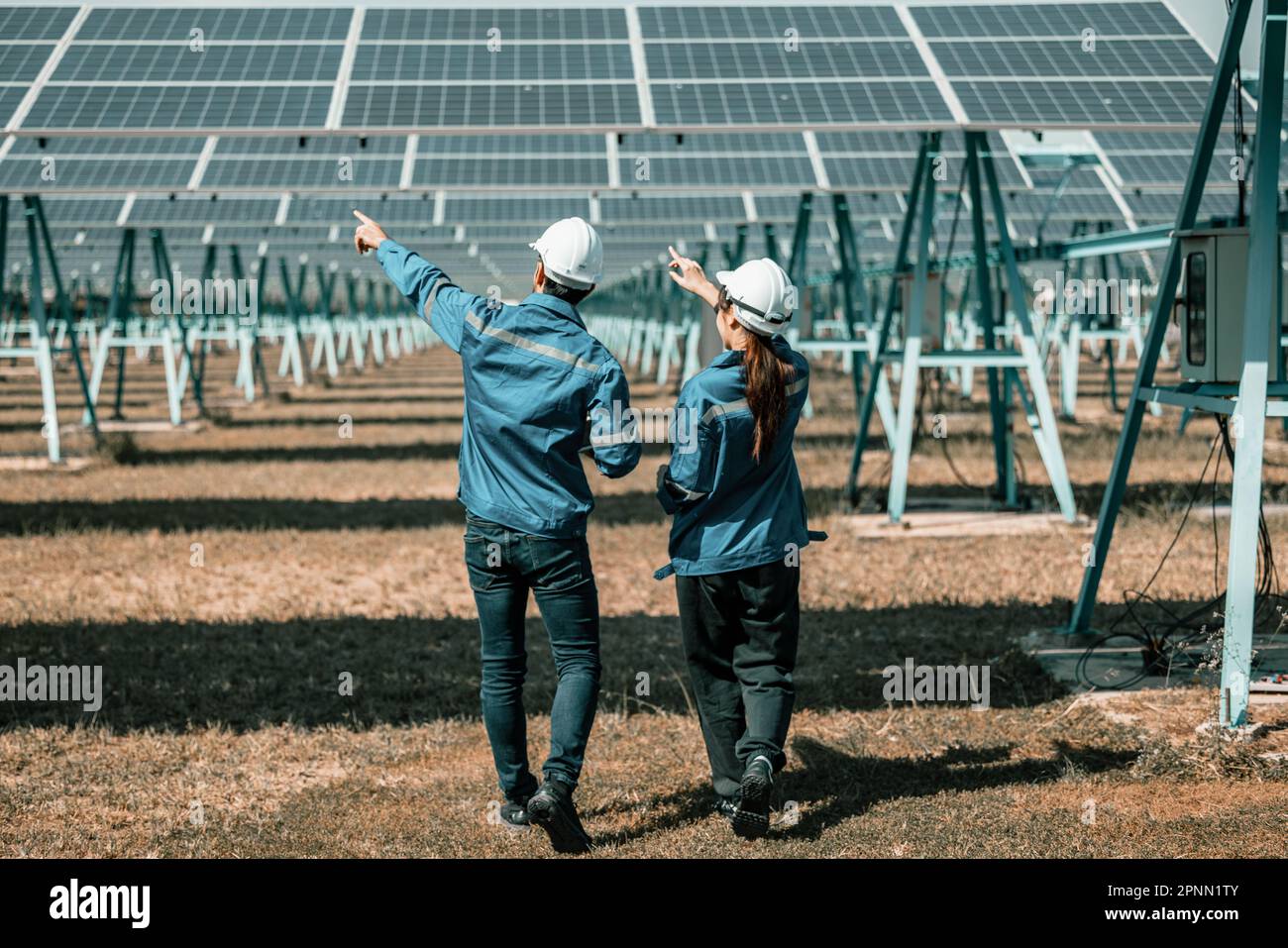 Solar design engineers visually inspect photovoltaic array installation ...