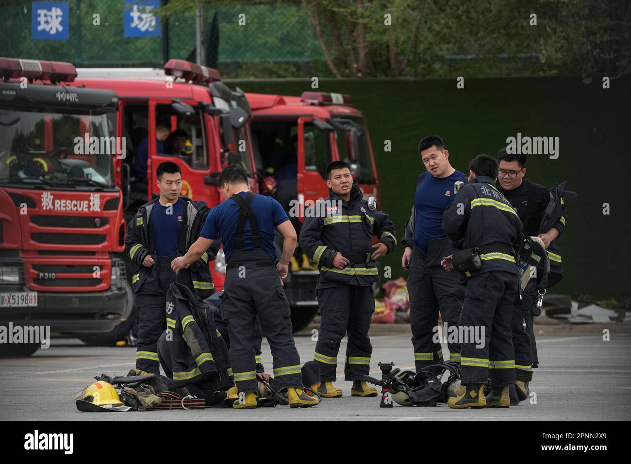 Firefighters take off their suits after conducting a fire drill at a ...