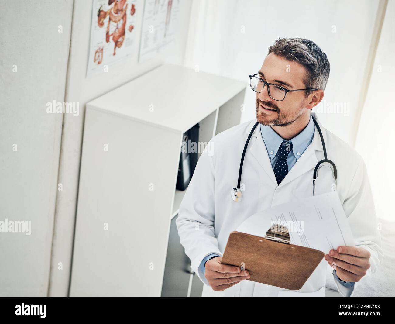 Paperwork is an essential part of his practice. a focussed doctor ...