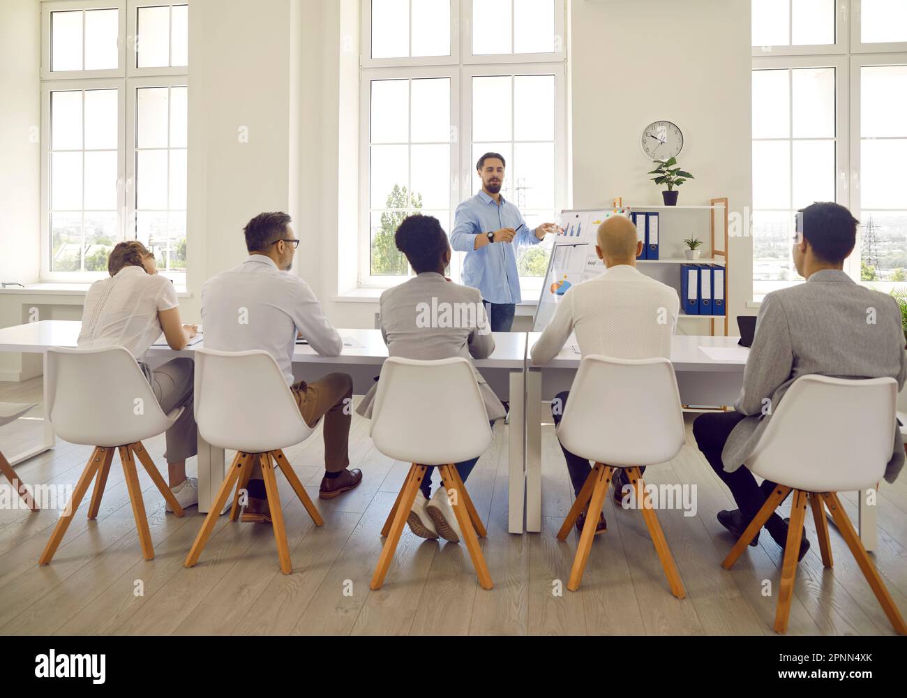 Corporate business team listening to man making presentation in front ...