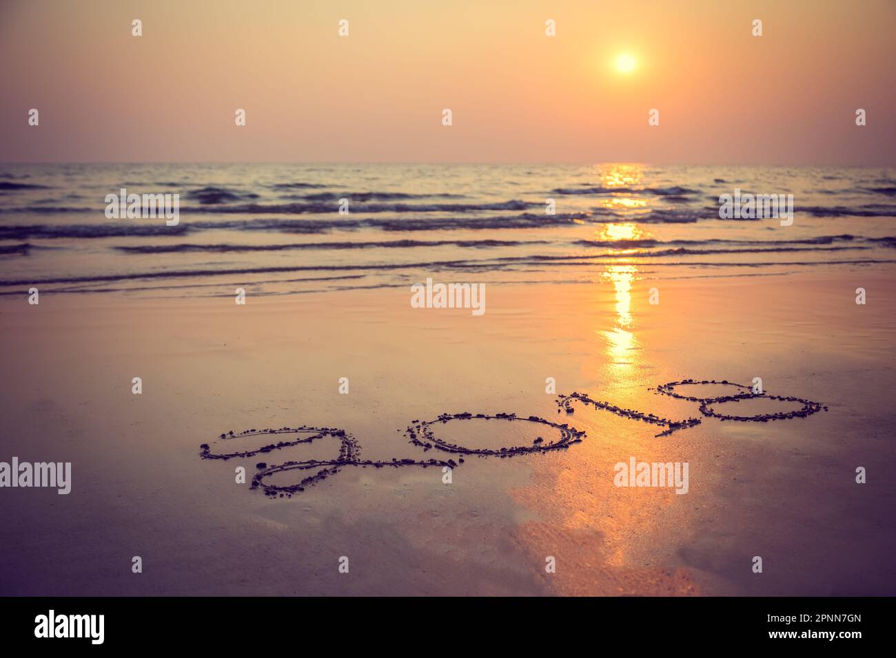 Numbers 2018 handwritten on sand at the beach during sunset time ...