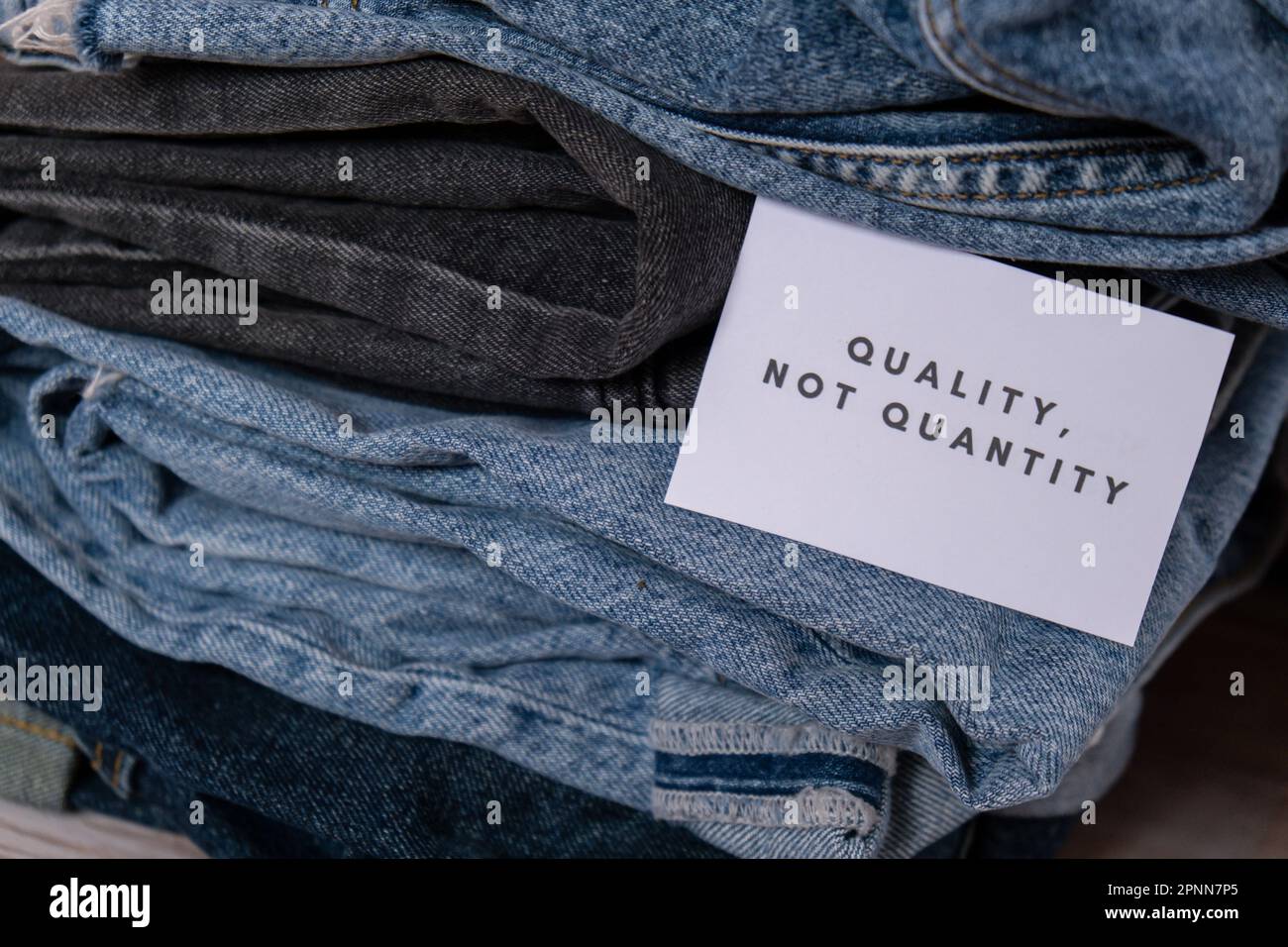 Quality not quantity text on paper note on Jeans clothes assortment ...