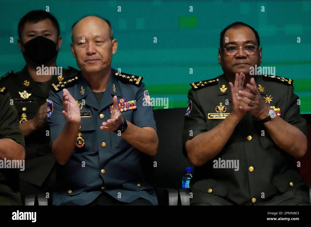 Gen. Sao Sokha, second right, commander of the Military Police, claps together with Gen. Hing ...