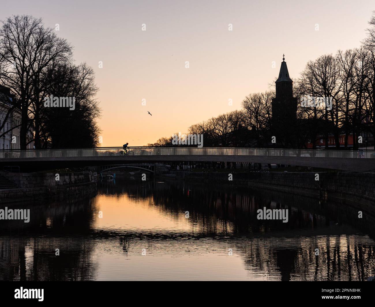 Silhouette of commuter on bicycle on kirjastosilta bridge in Turku ...