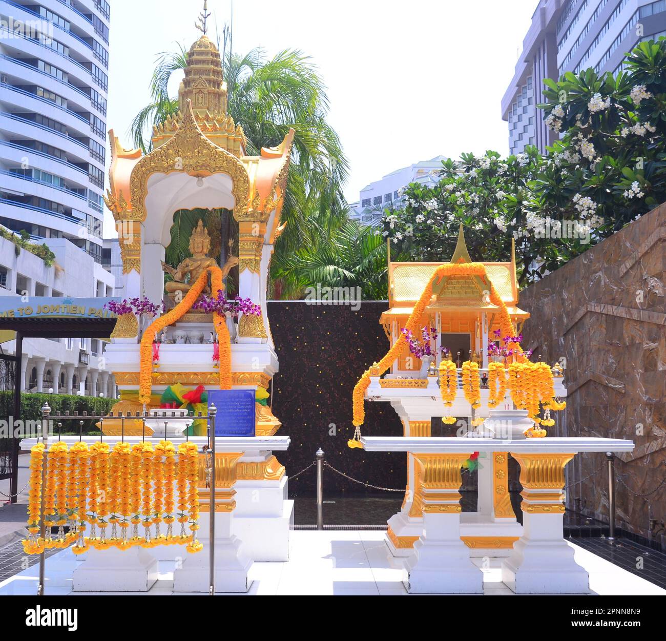 A typical Buddhist shrine, covered in flower garlands and decorations ...