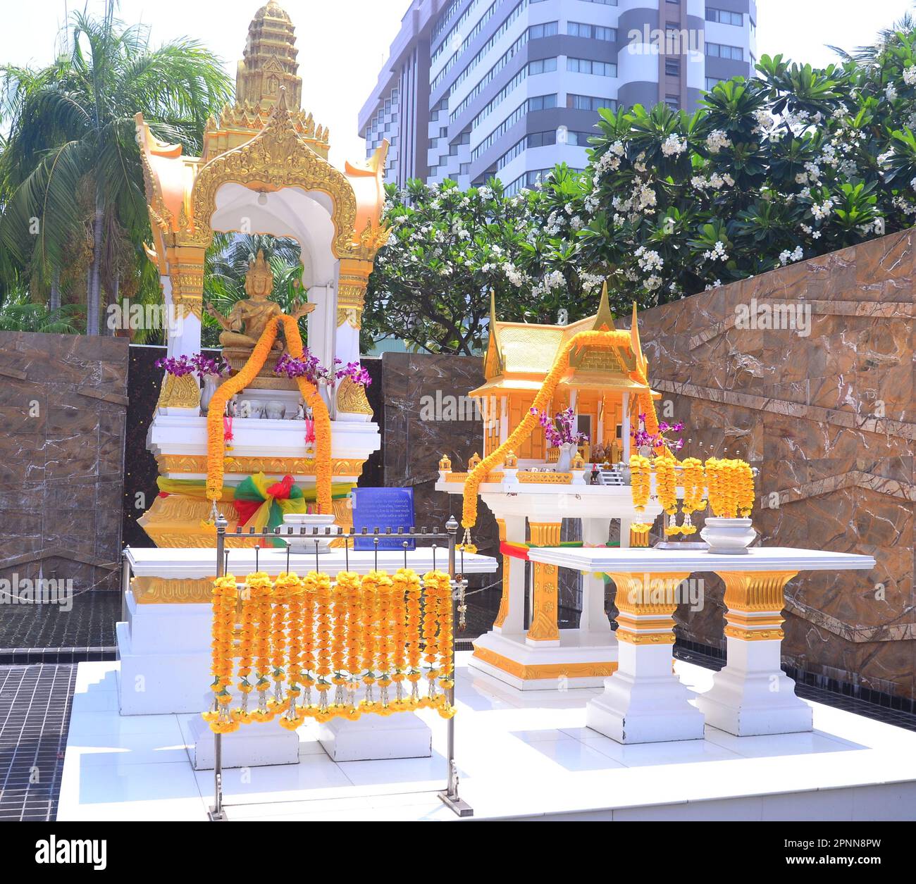 A typical Buddhist shrine, covered in flower garlands and decorations ...