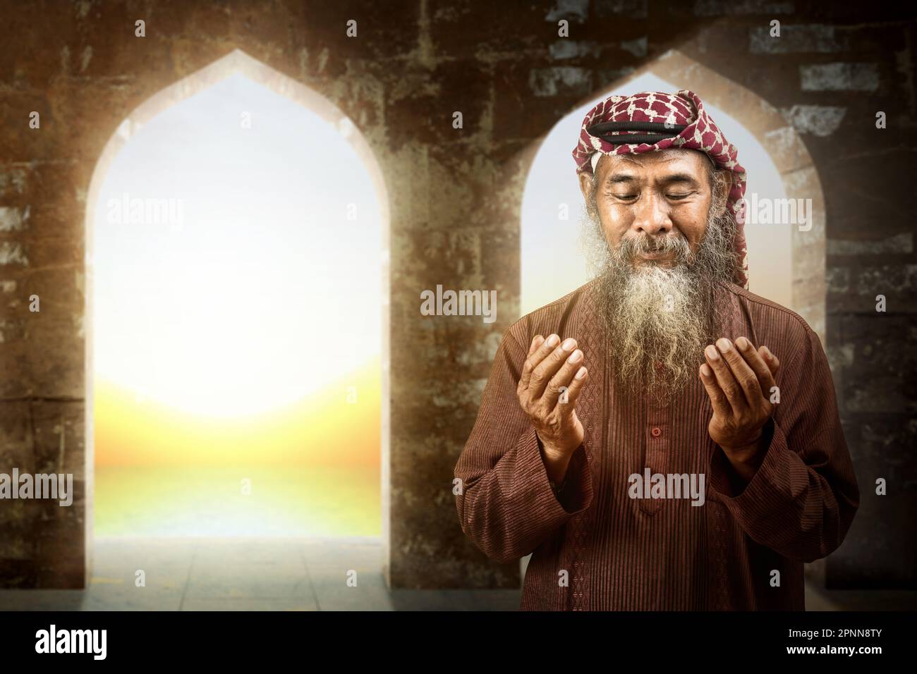 Muslim man with a beard wearing keffiyeh with agal in praying while ...