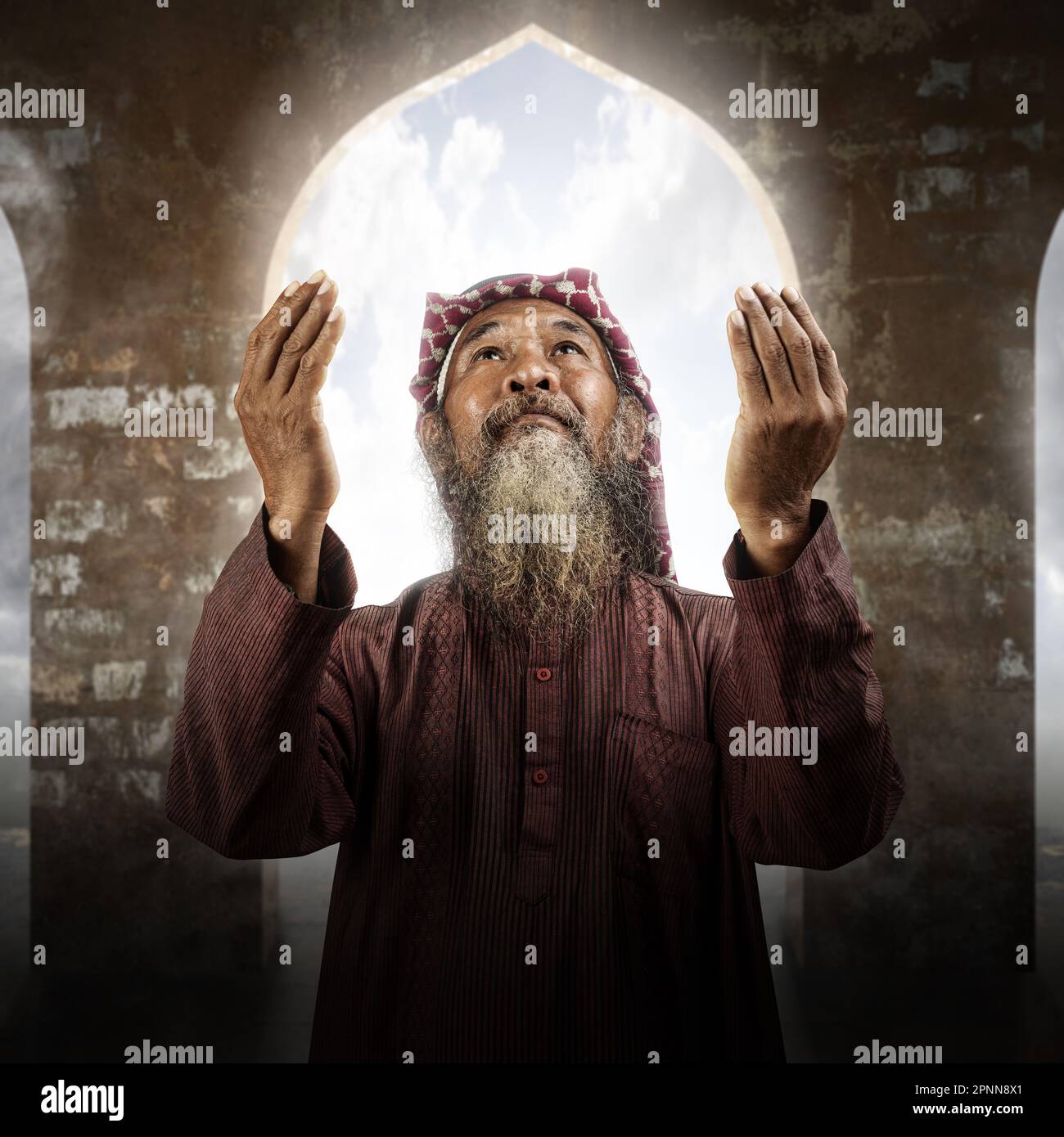 Muslim man with a beard wearing keffiyeh with agal in praying while ...