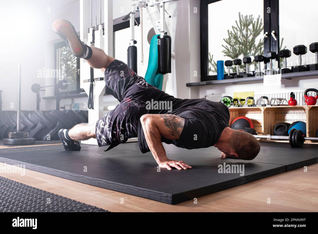 A young male athlete performing a handstand exercise in a gym Stock ...