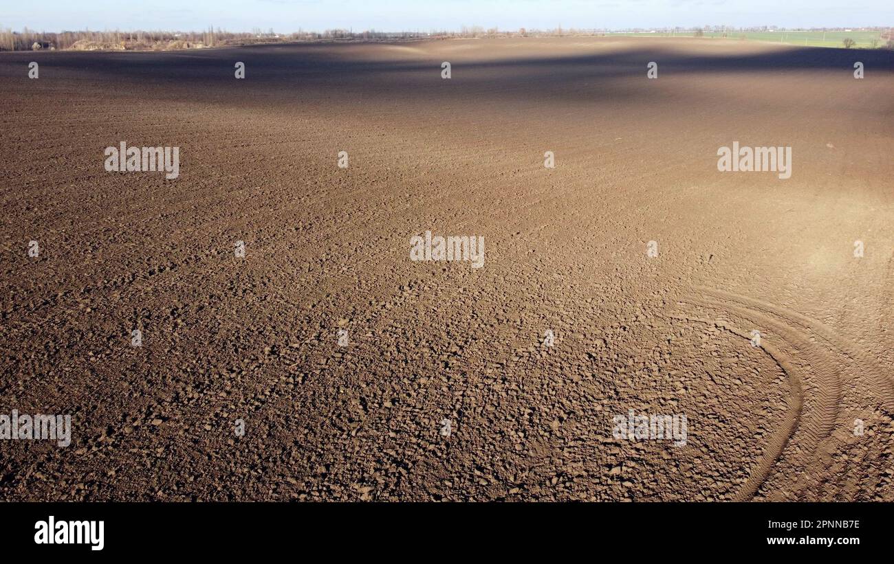 Landscape of plowed up land on agricultural field with cloud shadows on ...